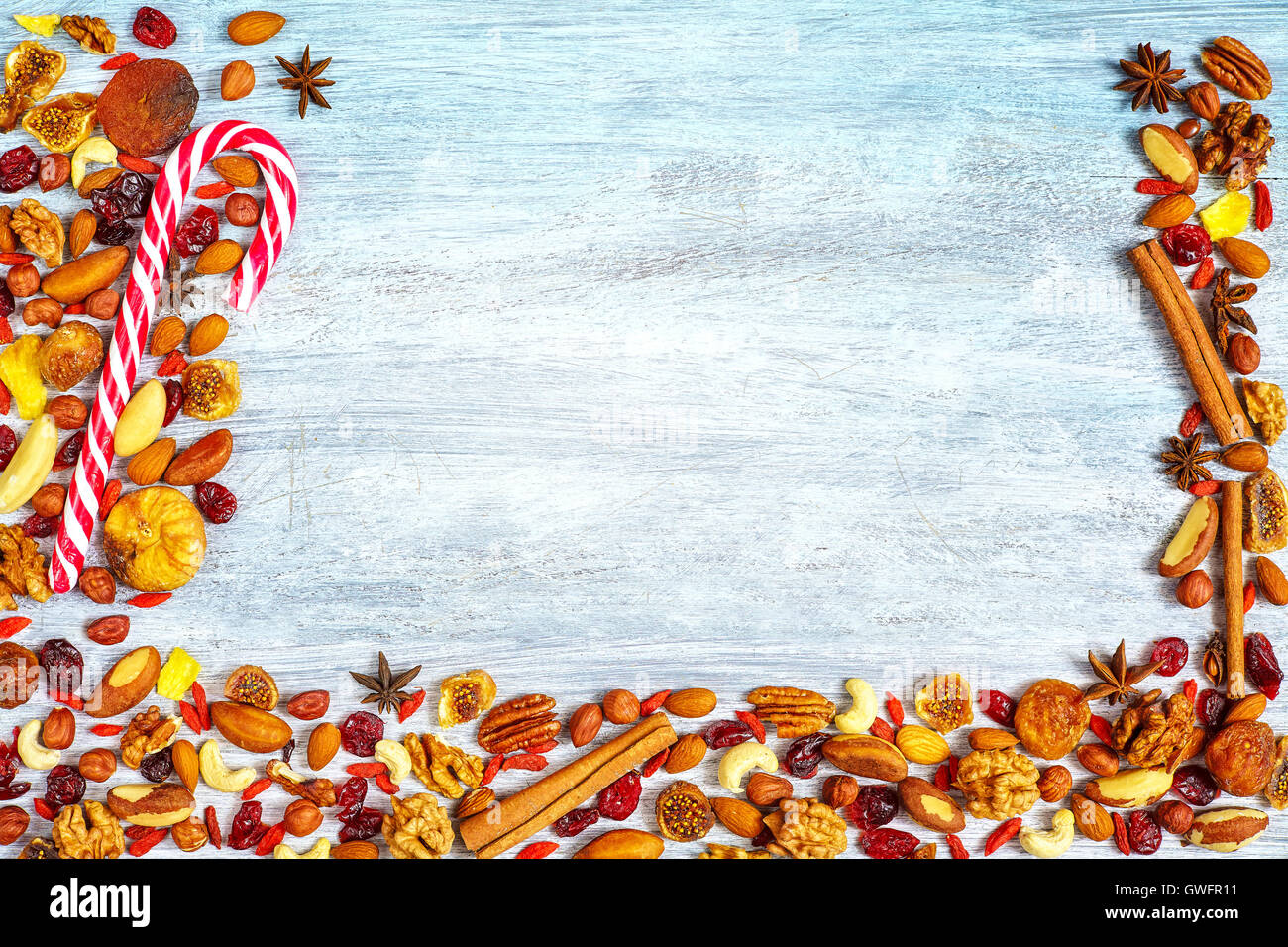 Nuts and dried fruits on a rustic wooden table, top view with copy ...