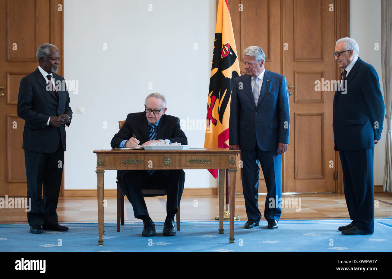 Former Finnish president Martti Ahtisaari (2.f.l) signs the guest book ...