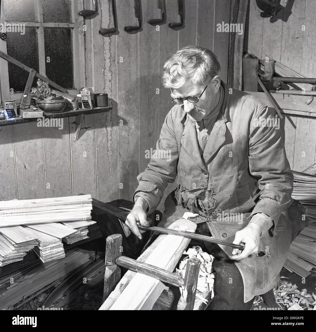 1950s, historical, carpenter in workshop planing or smoothing a piece ...