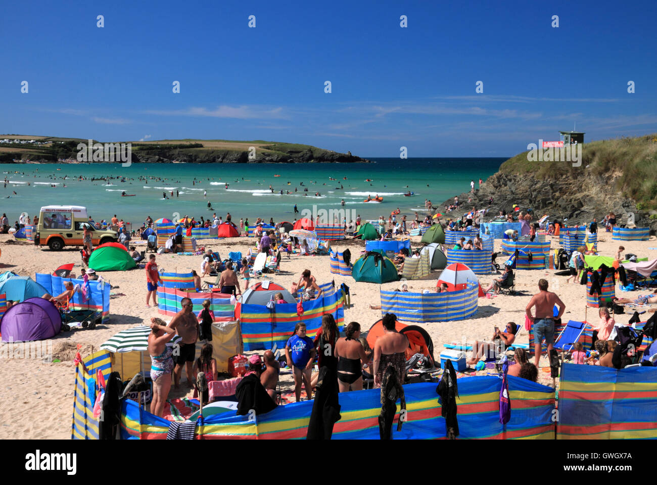 A beach crowded with holidaymakers and windbreaks at Harlyn Bay, North ...