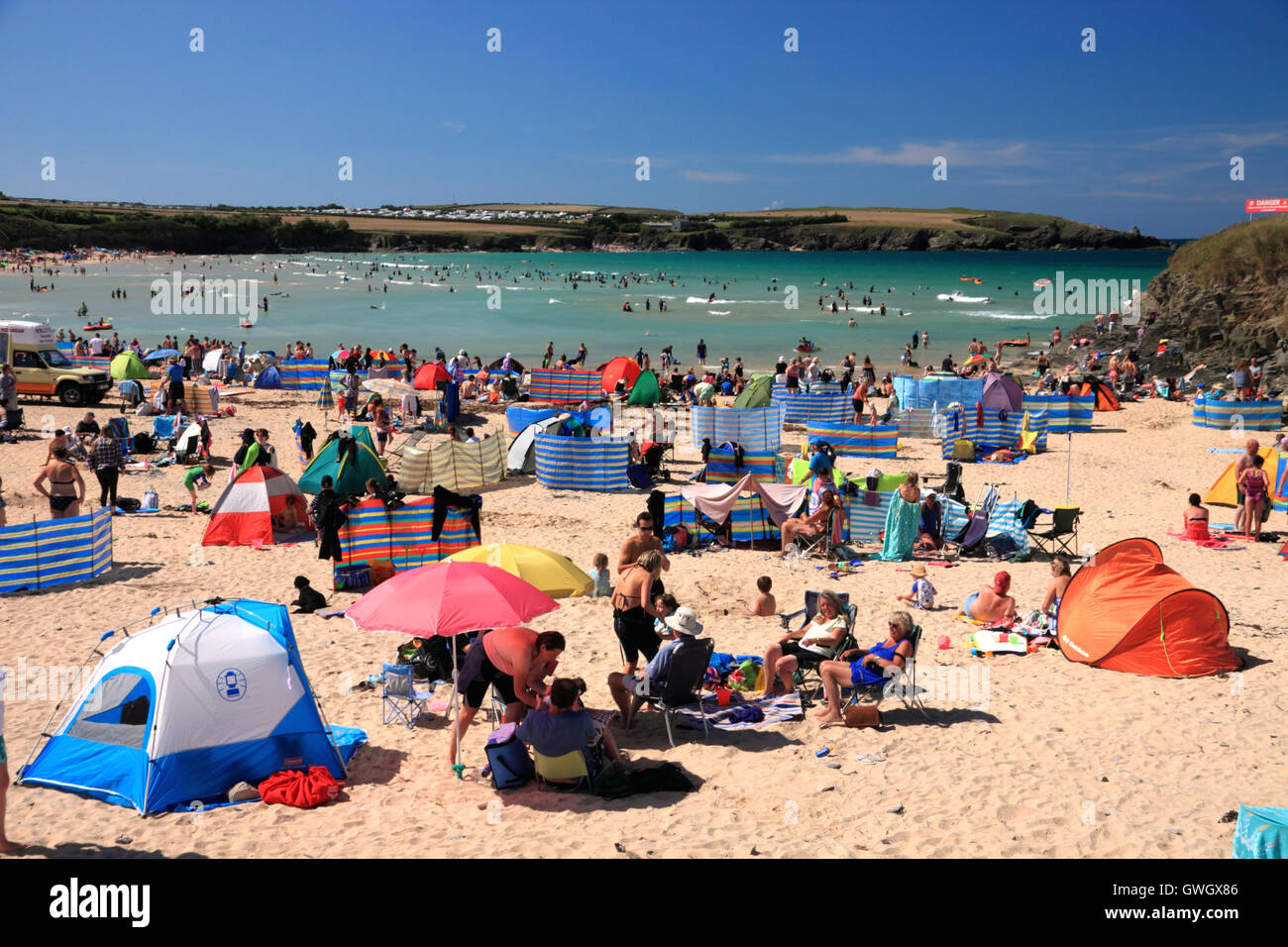 A beach crowded with holidaymakers and windbreaks at Harlyn Bay, North ...