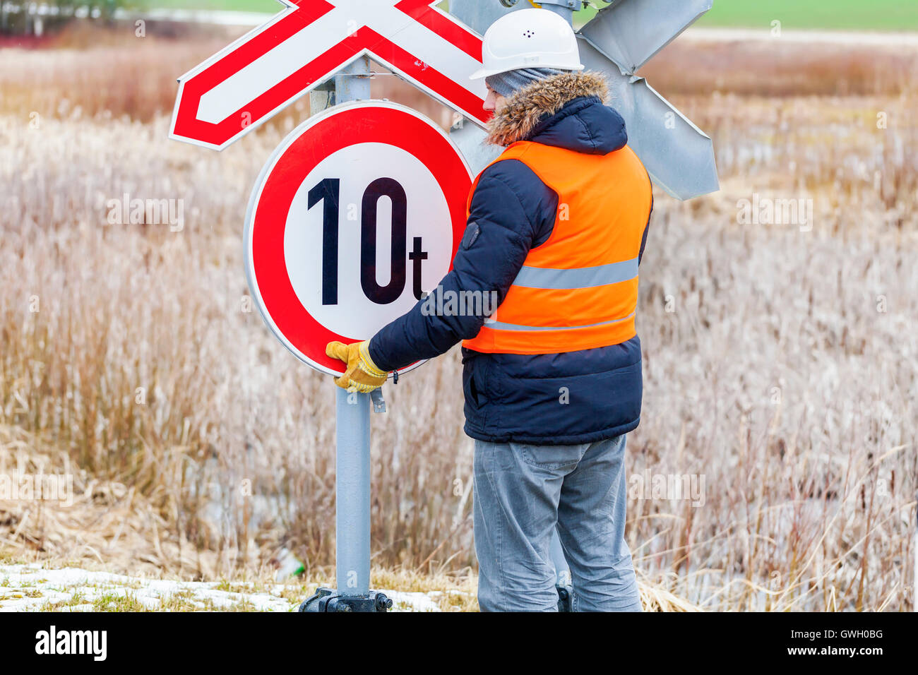 Worker try to fix road sign Stock Photo - Alamy