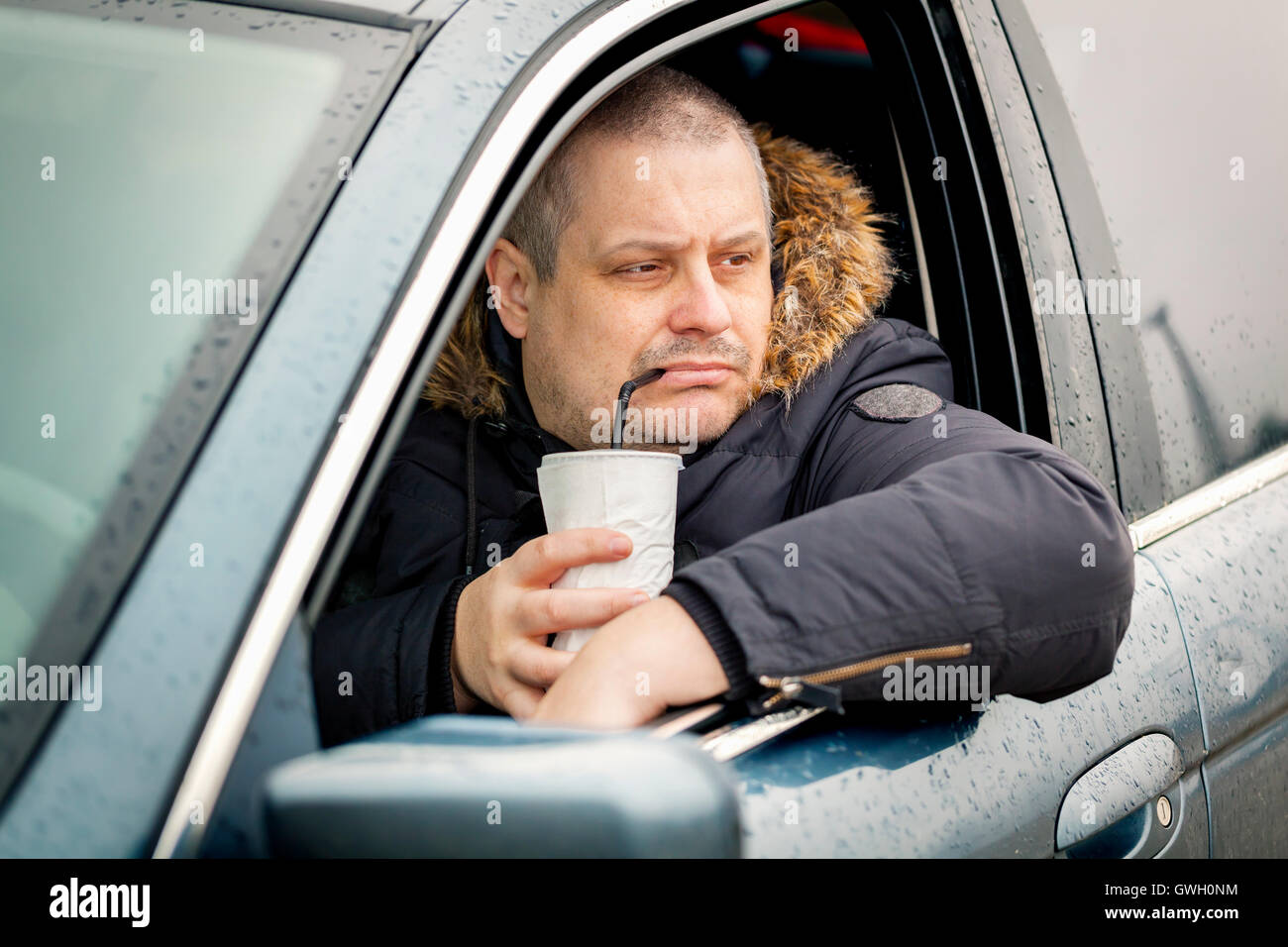 Man sitting in the car and drinking soda Stock Photo - Alamy
