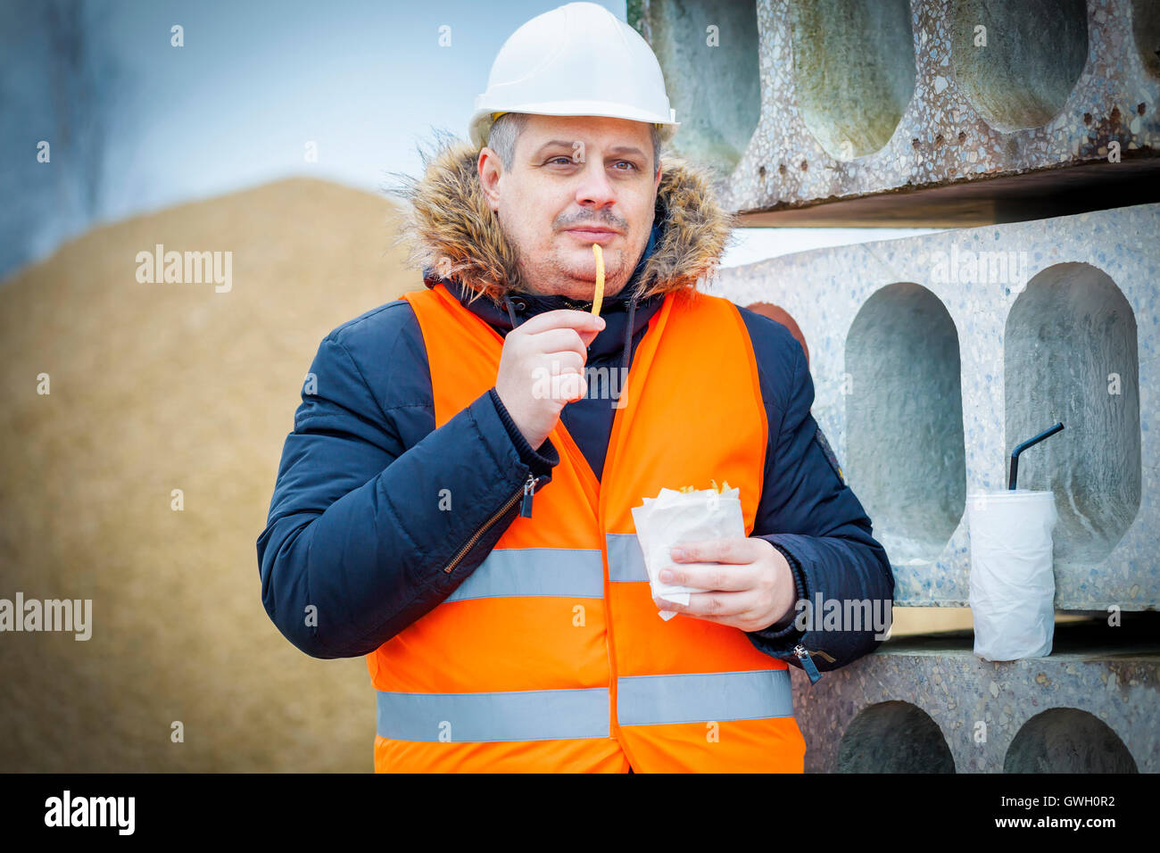 Worker eating french fries at construction site Stock Photo - Alamy