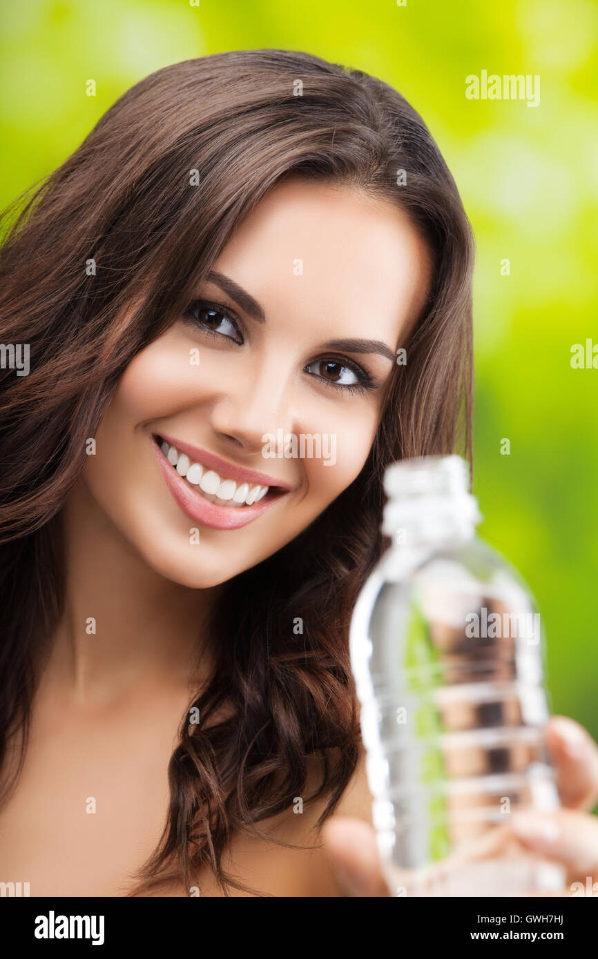 Portrait of woman showing bottle of water, outdoor Stock Photo - Alamy