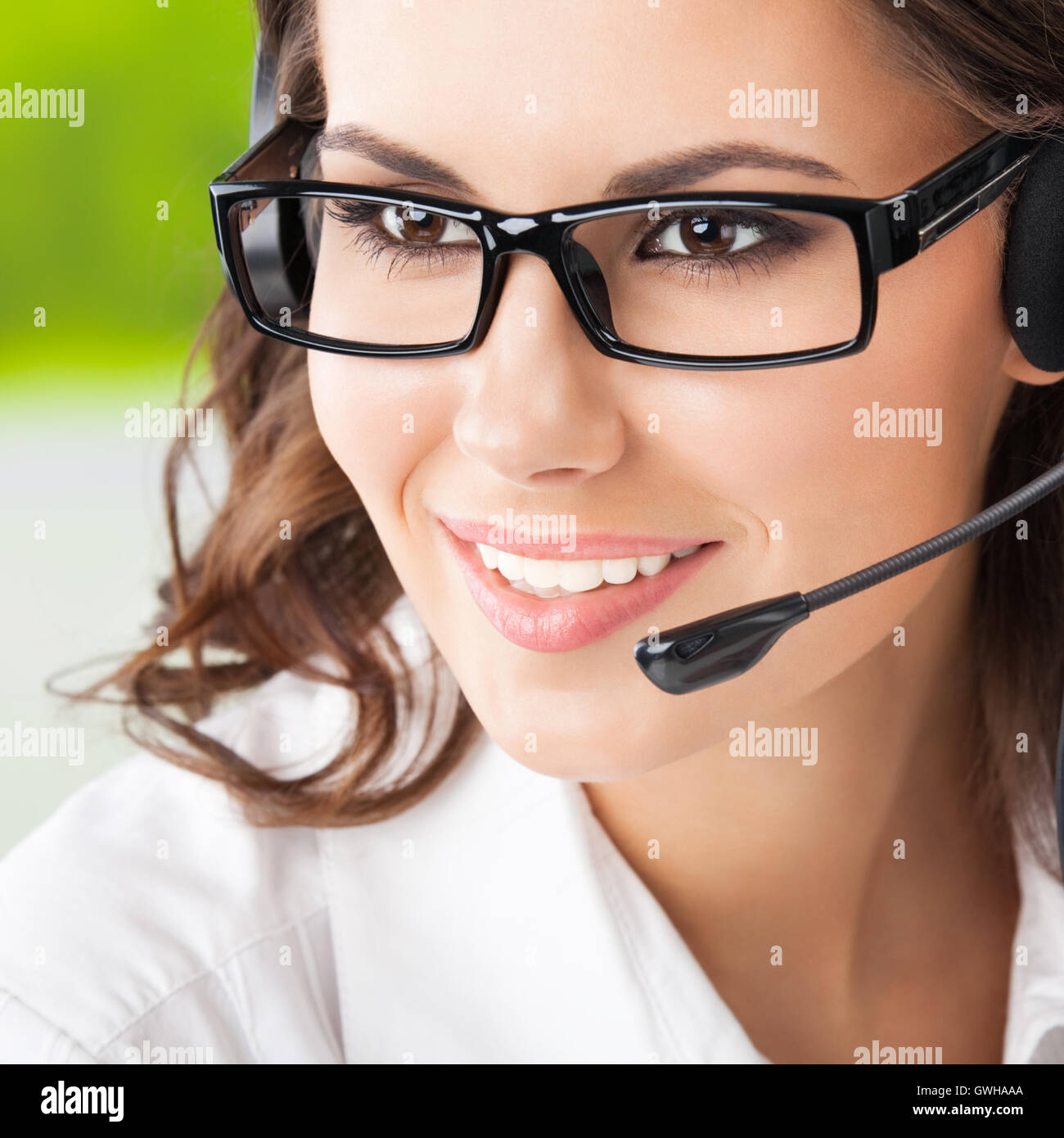 Portrait of happy smiling cheerful beautiful young support phone operator in headset Stock Photo ...