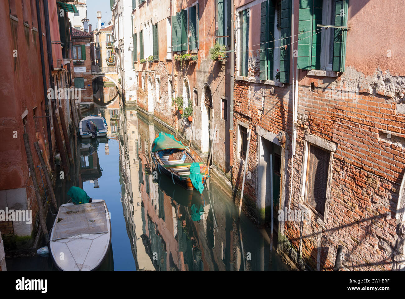 Boats on backwater canal in Venice Italy Stock Photo - Alamy