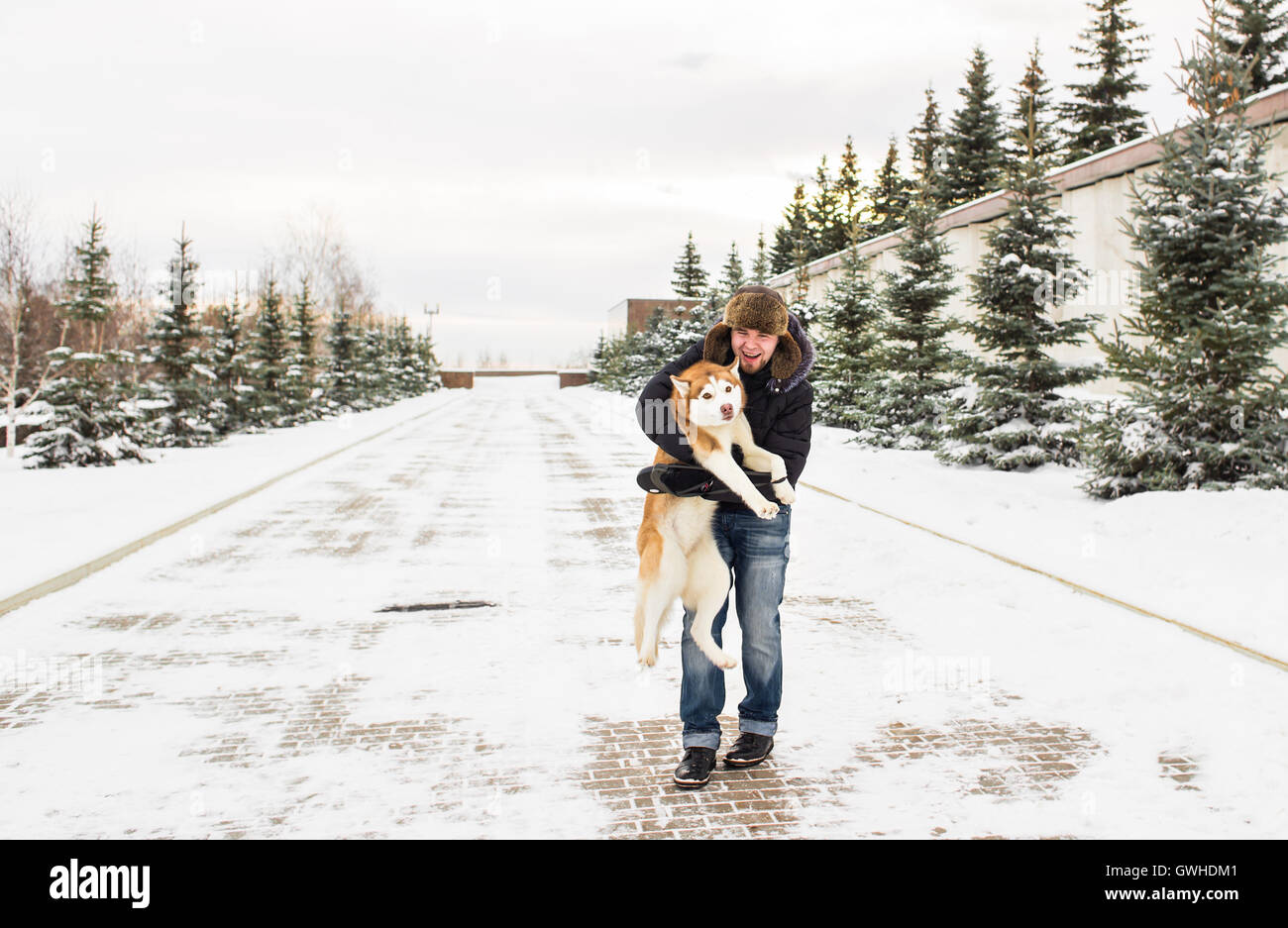 Guy with dog winter outdoors fun Stock Photo - Alamy
