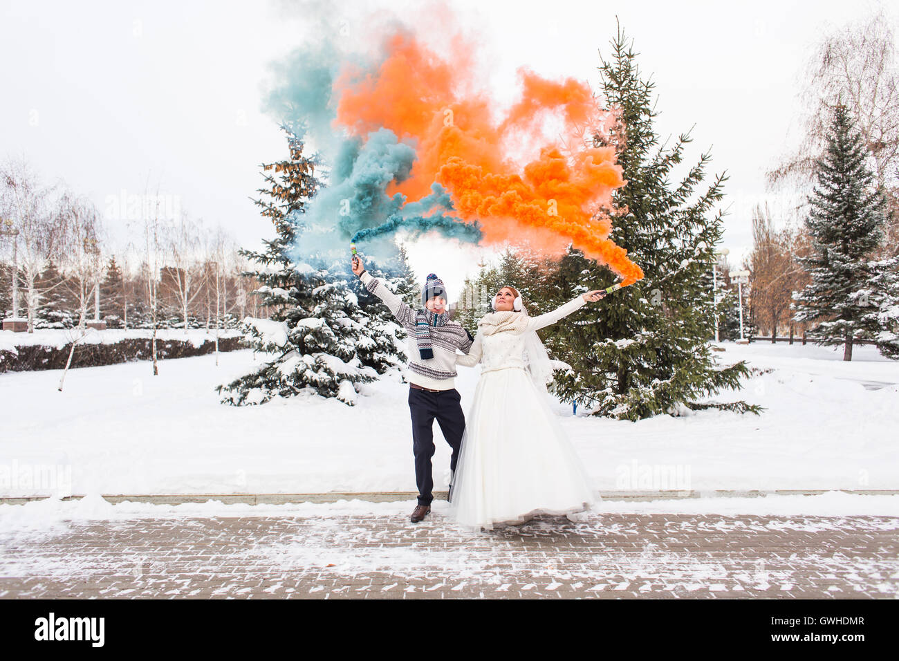 The bride and groom with smoke bombs in winter Stock Photo - Alamy