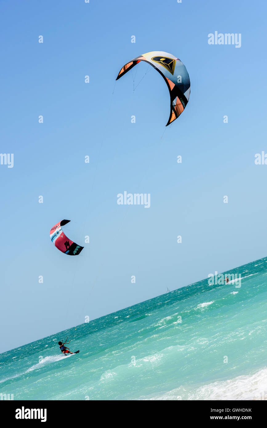 Vertical view of kiteboarders in the sea under bright sunshine ...