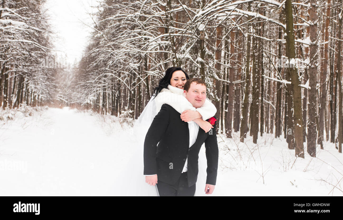 Man giving woman piggyback ride on winter vacation in snowy forest ...