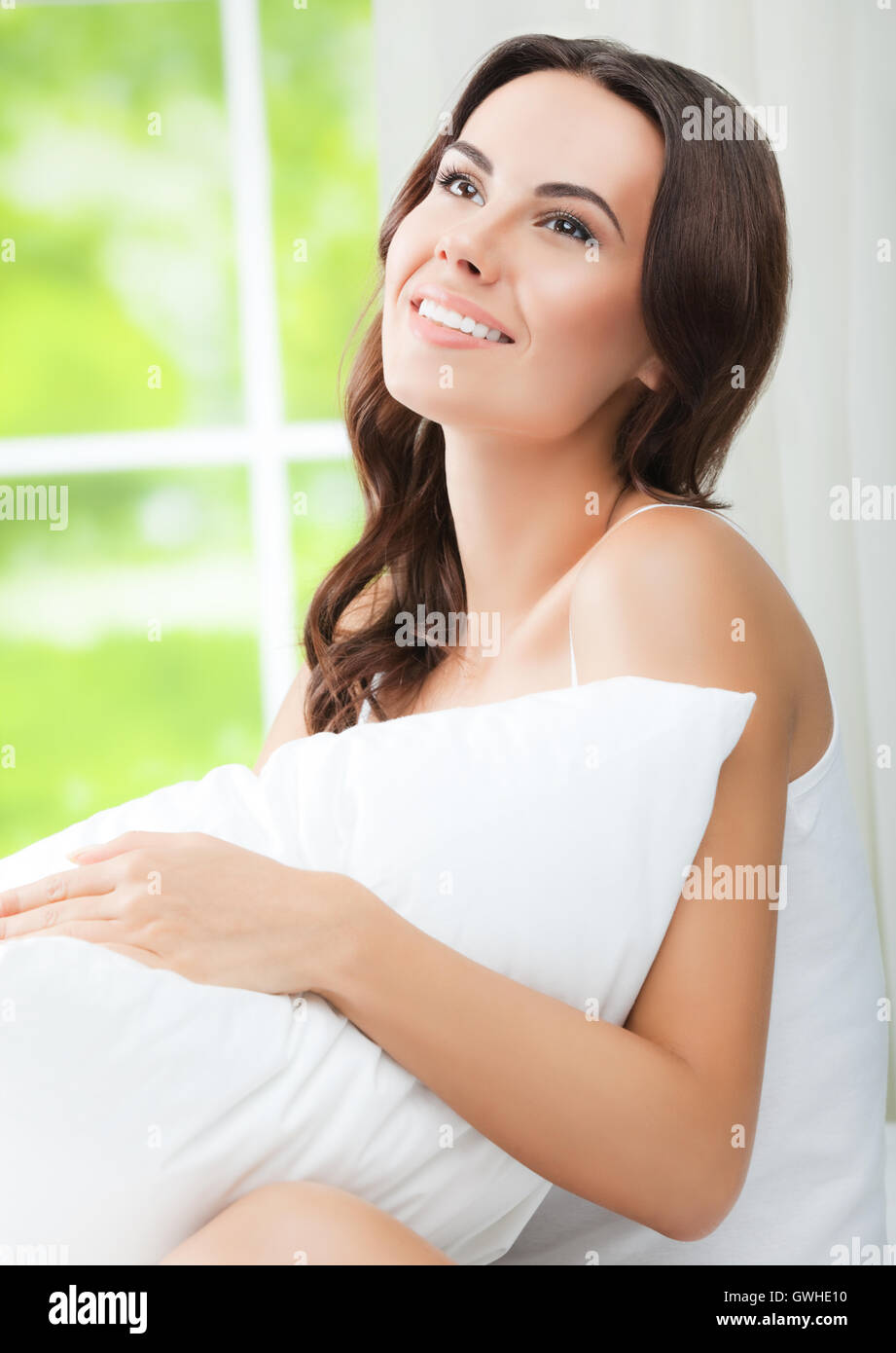 Young beautiful woman brunette waking up with pillow, at bedroom Stock ...