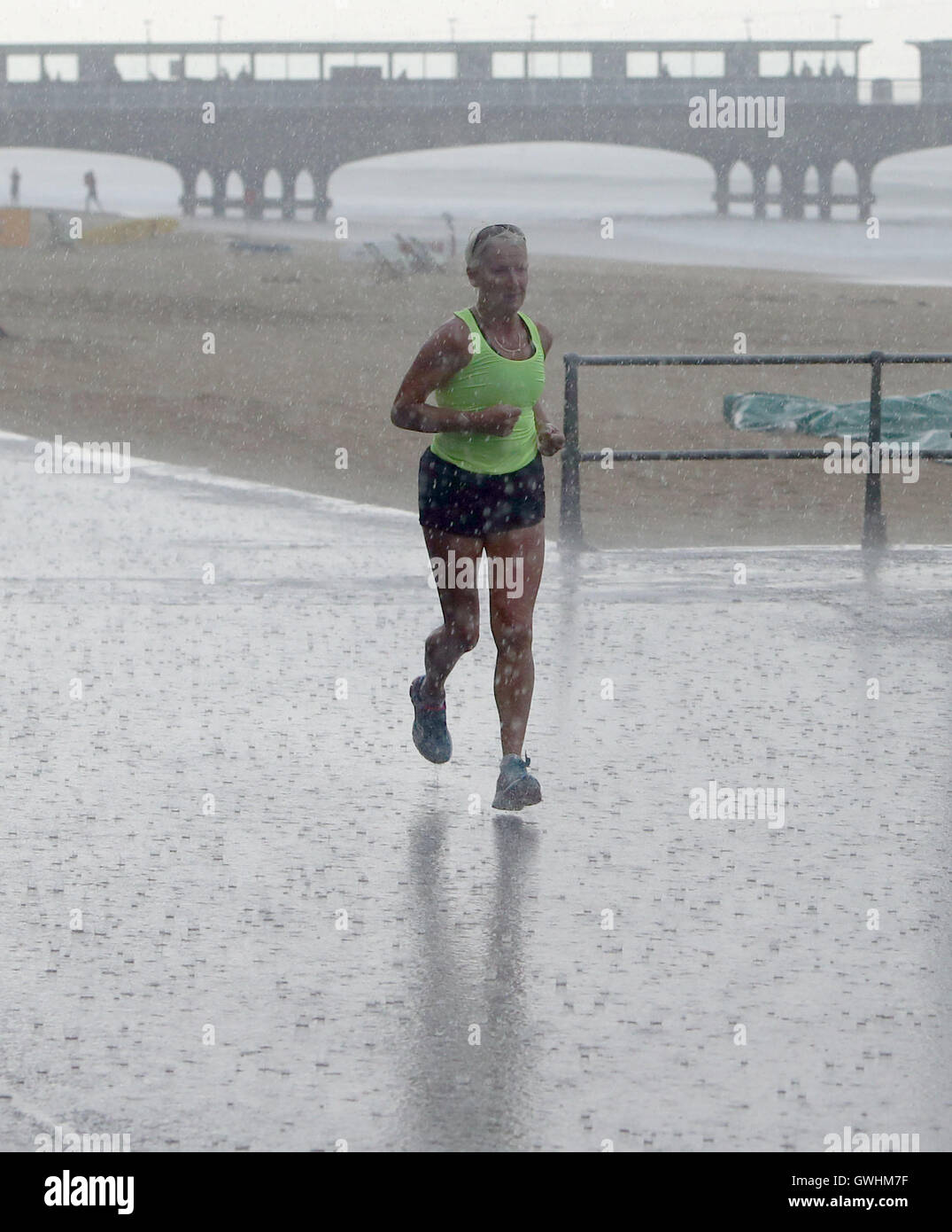A jogger braves the rain as a thunder and lightning storm passes over ...