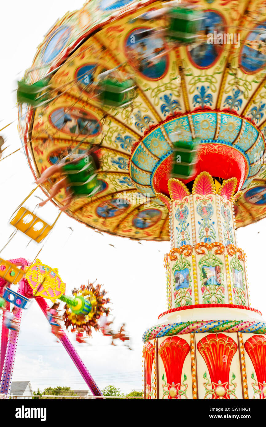 Children riding a colorful merry-go-round at the county fair Stock ...