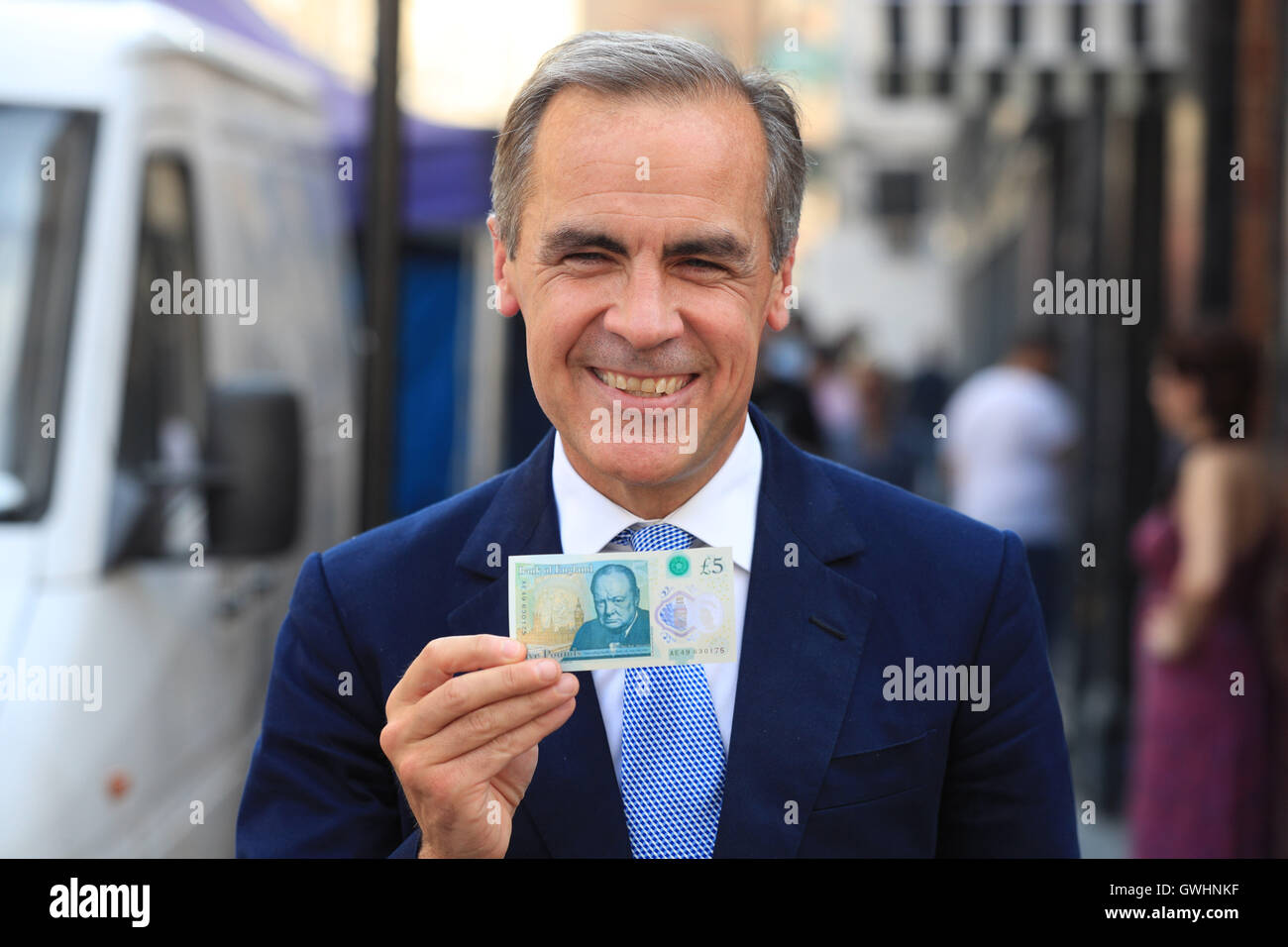 Bank of England Governor Mark Carney holds a new plastic £5 note as he ...