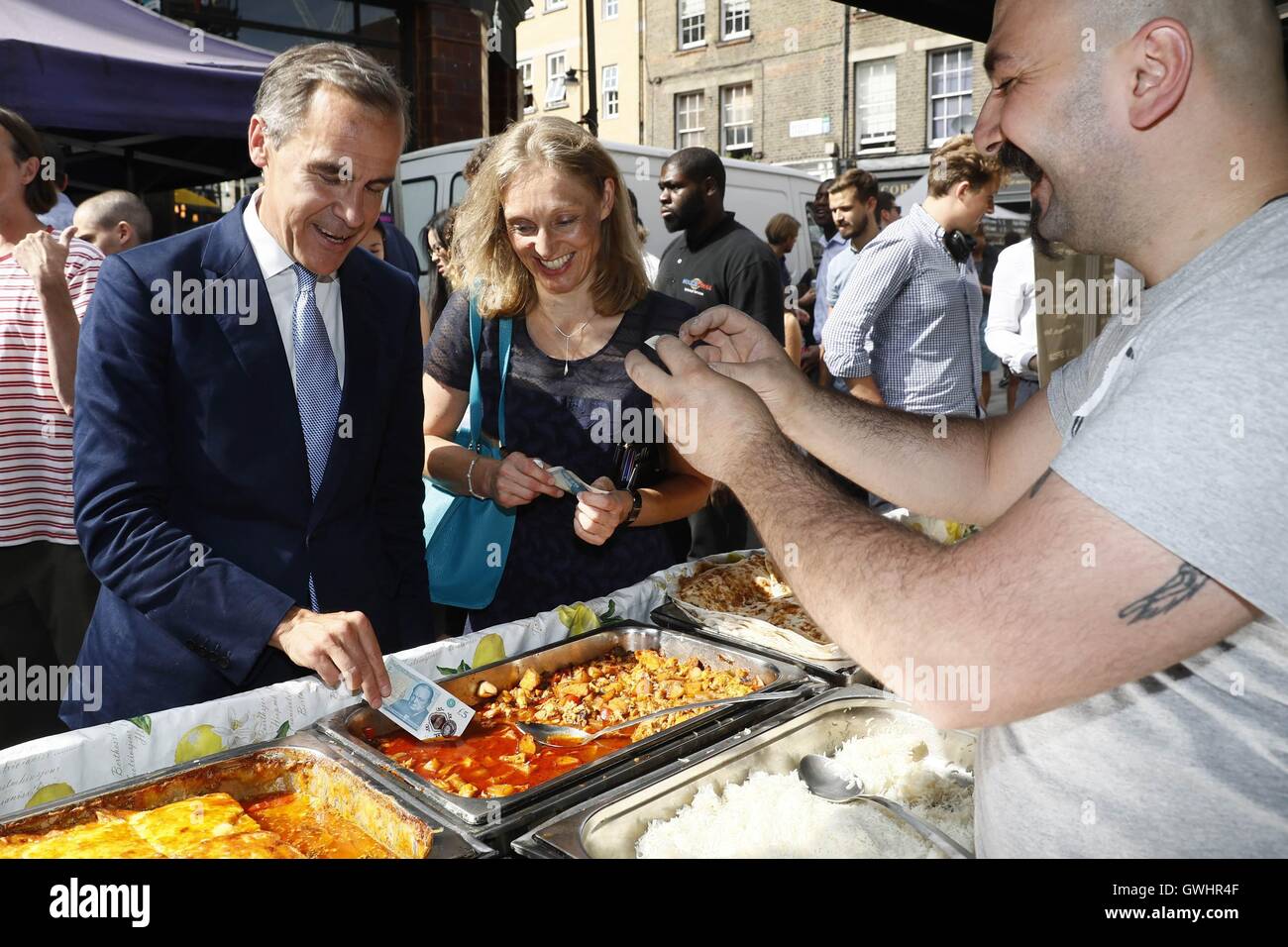 Bank of England Governor Mark Carney (left) dips a new plastic £5 note ...