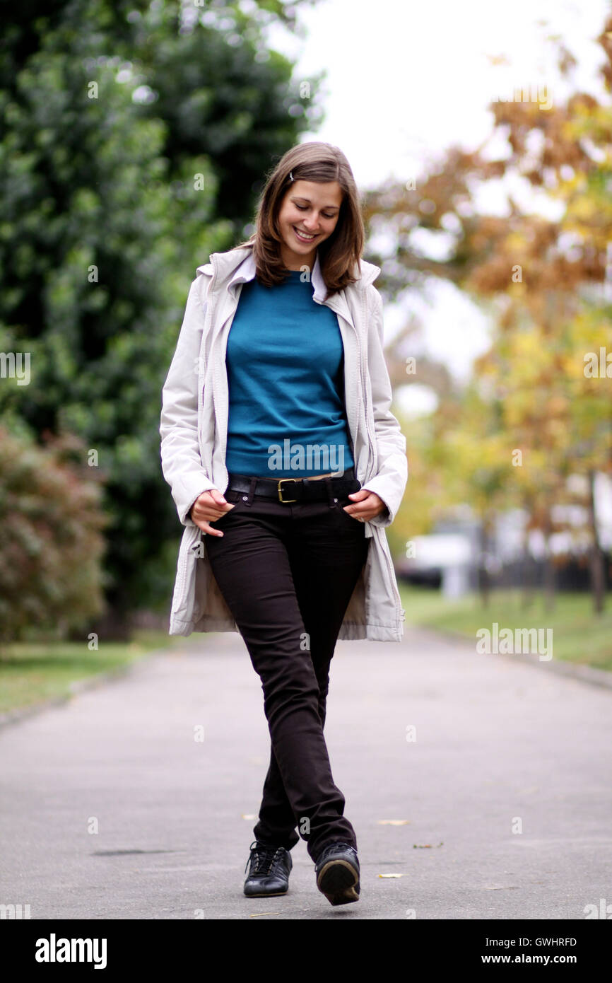 Full length, walking woman in autumn park Stock Photo - Alamy