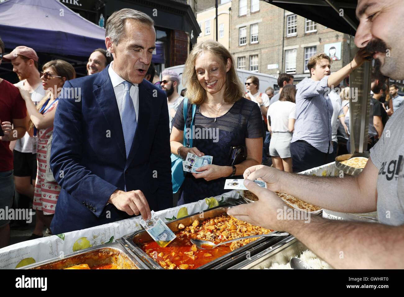 Bank of England Governor Mark Carney (left) dips a new plastic £5 note ...