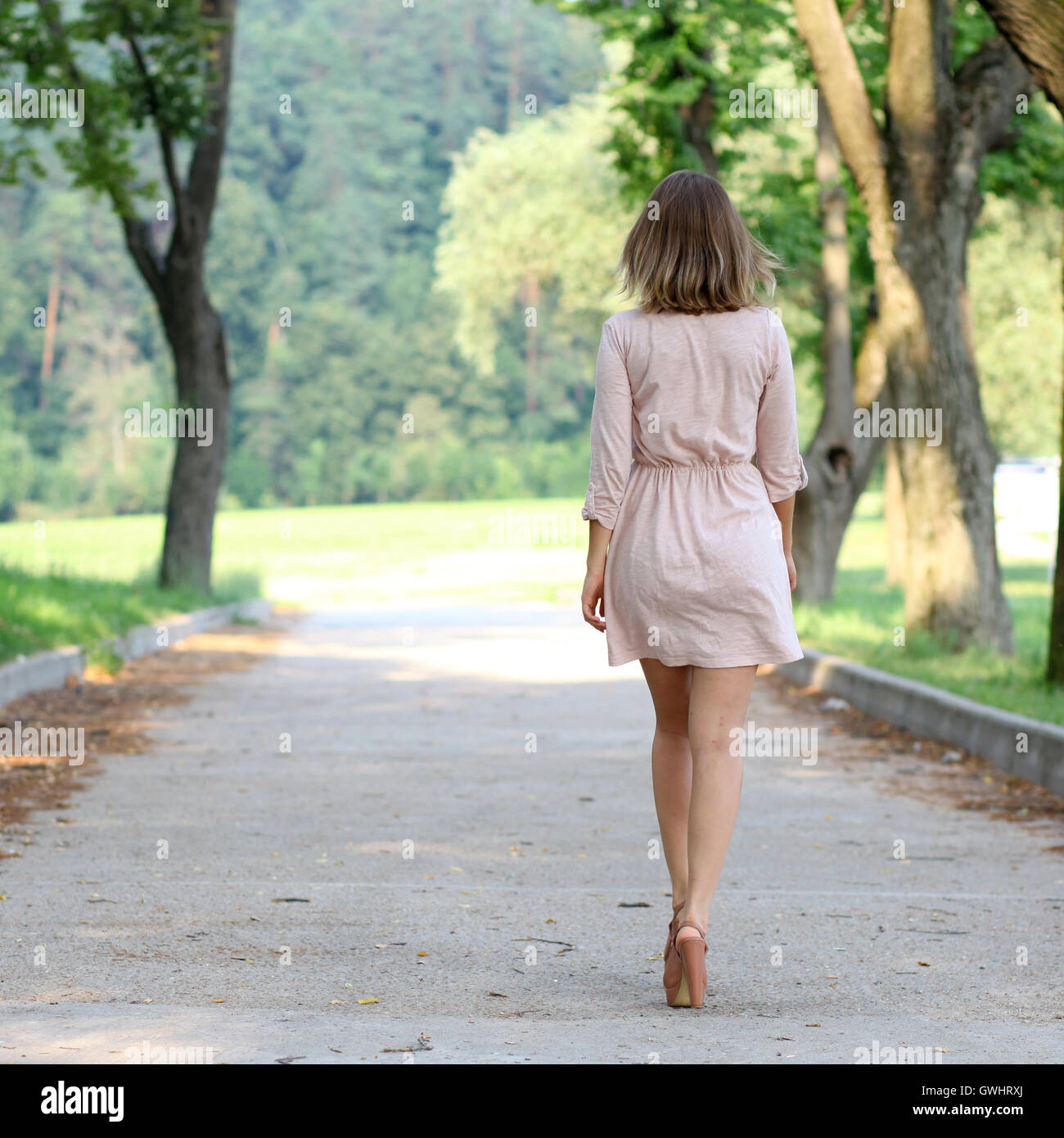 Beautiful young woman walking on the summer park Stock Photo - Alamy