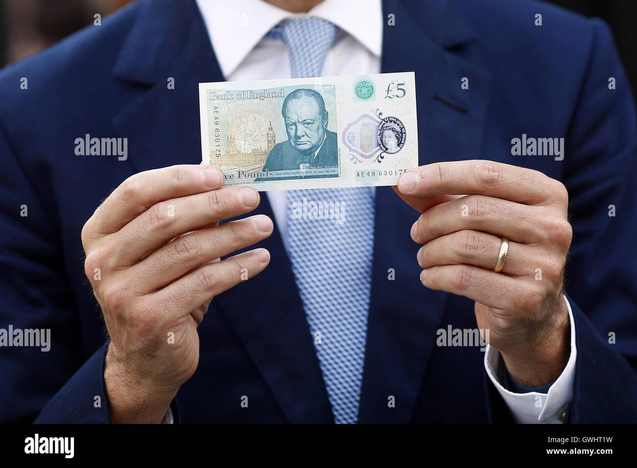 Bank of England Governor Mark Carney holds a new plastic £5 note as he ...