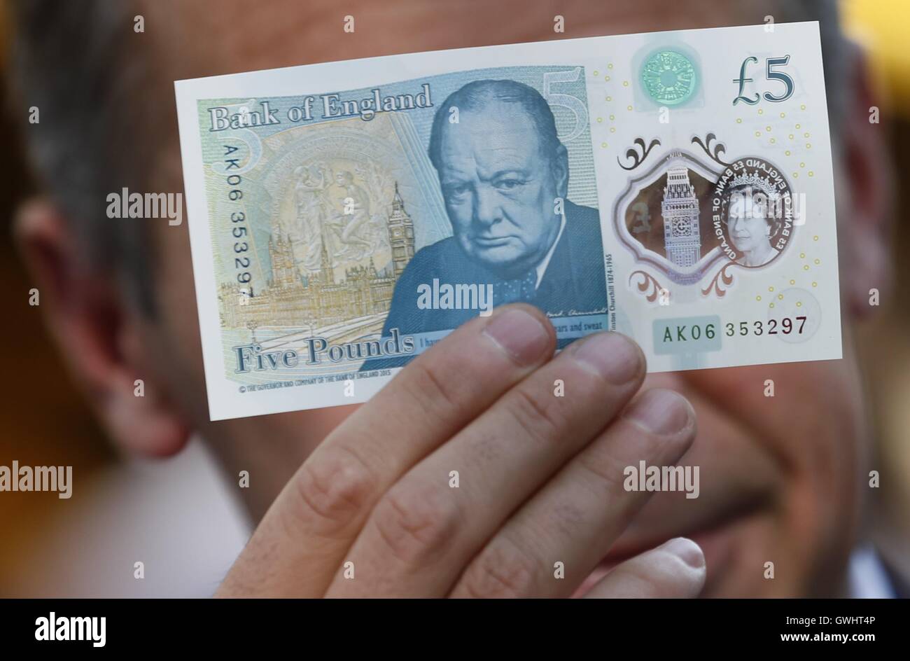 Bank of England Governor Mark Carney holds a new plastic £5 note as he ...