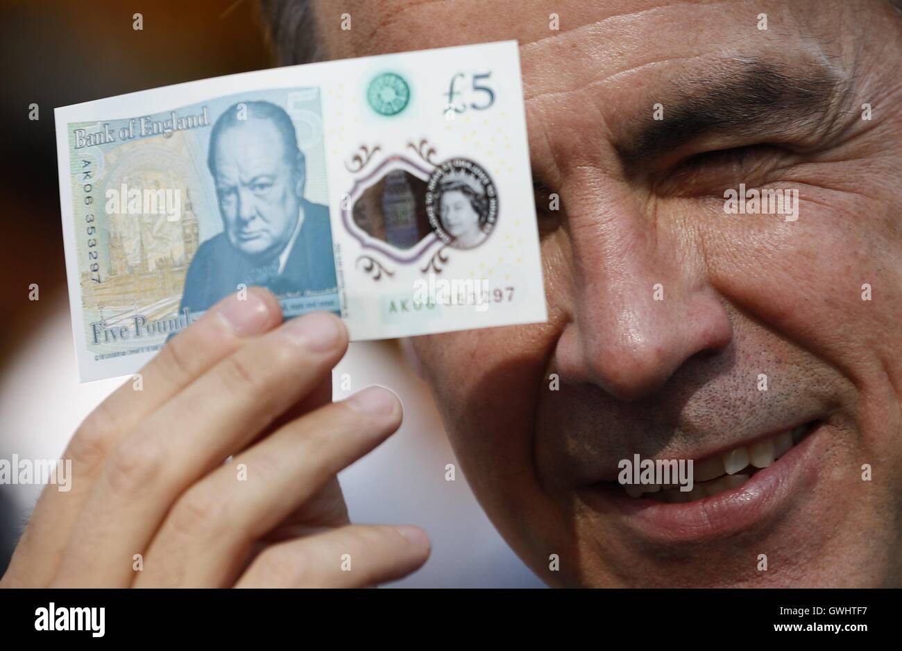 Bank of England Governor Mark Carney holds a new plastic Â£5 note as he ...