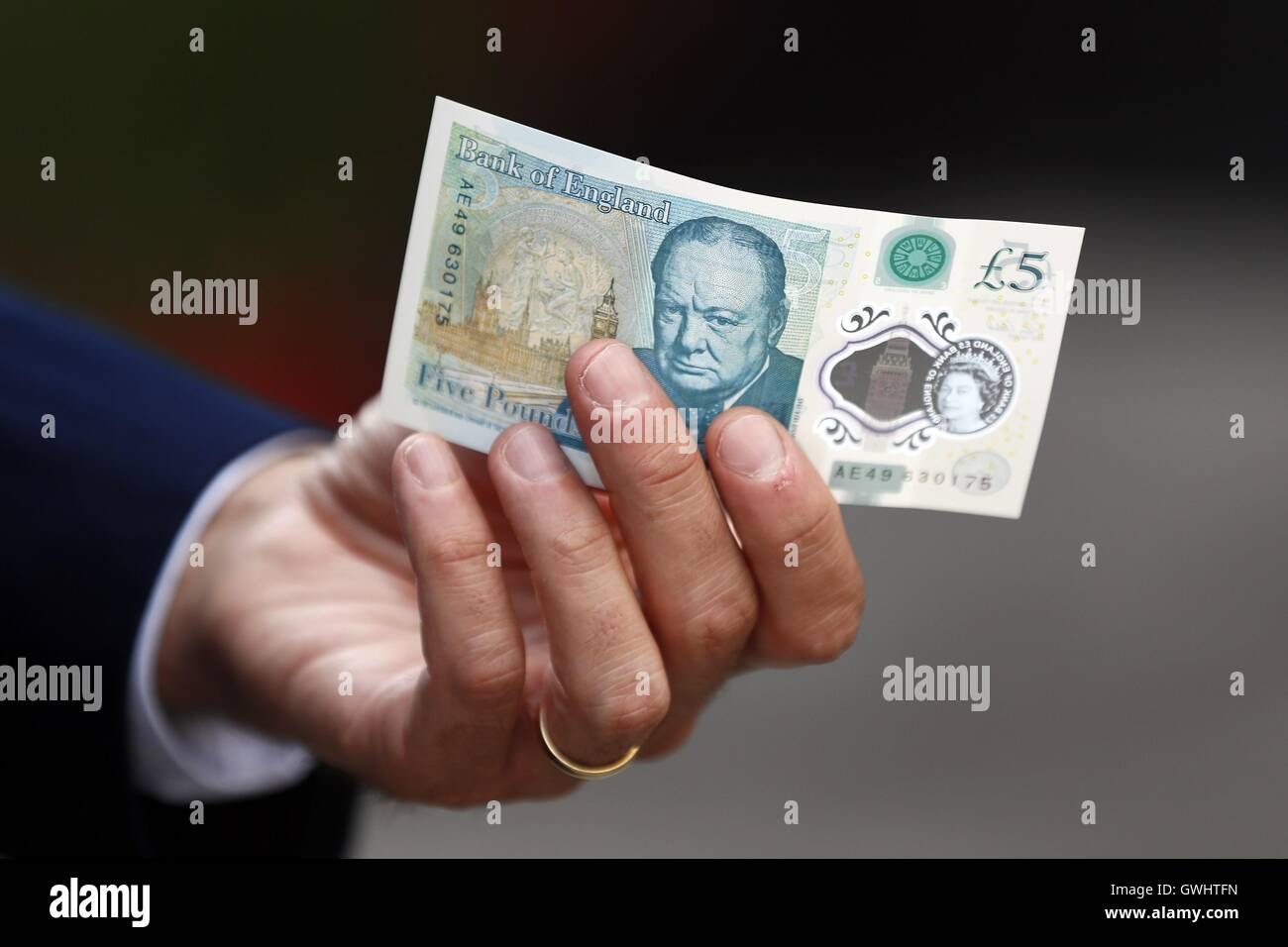 Bank of England Governor Mark Carney holds a new plastic £5 note as he ...