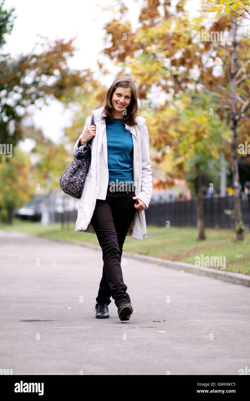 Full length, walking woman in autumn park Stock Photo - Alamy