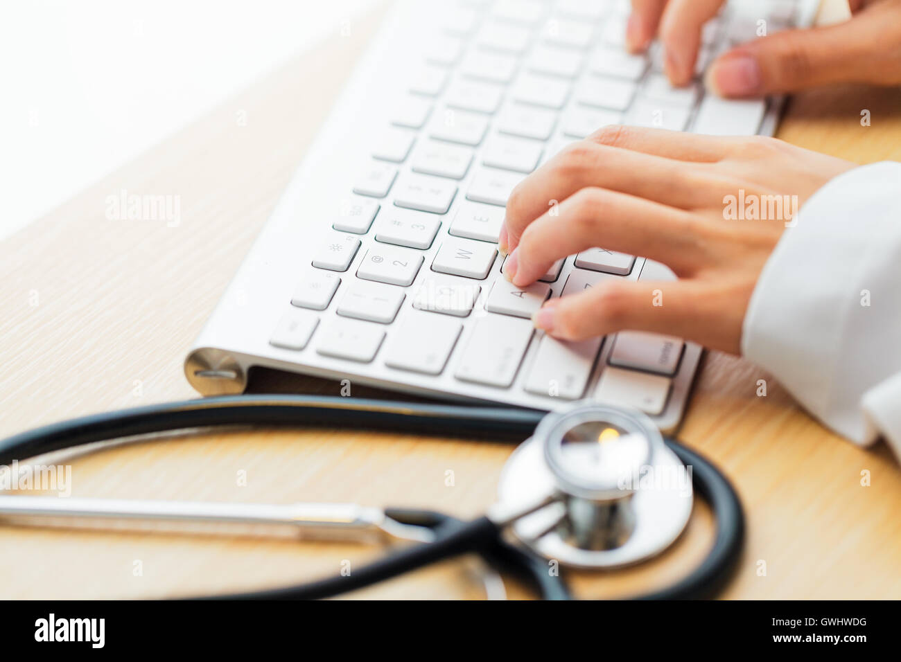 Doctor typing keyboard with stethoscope Stock Photo - Alamy