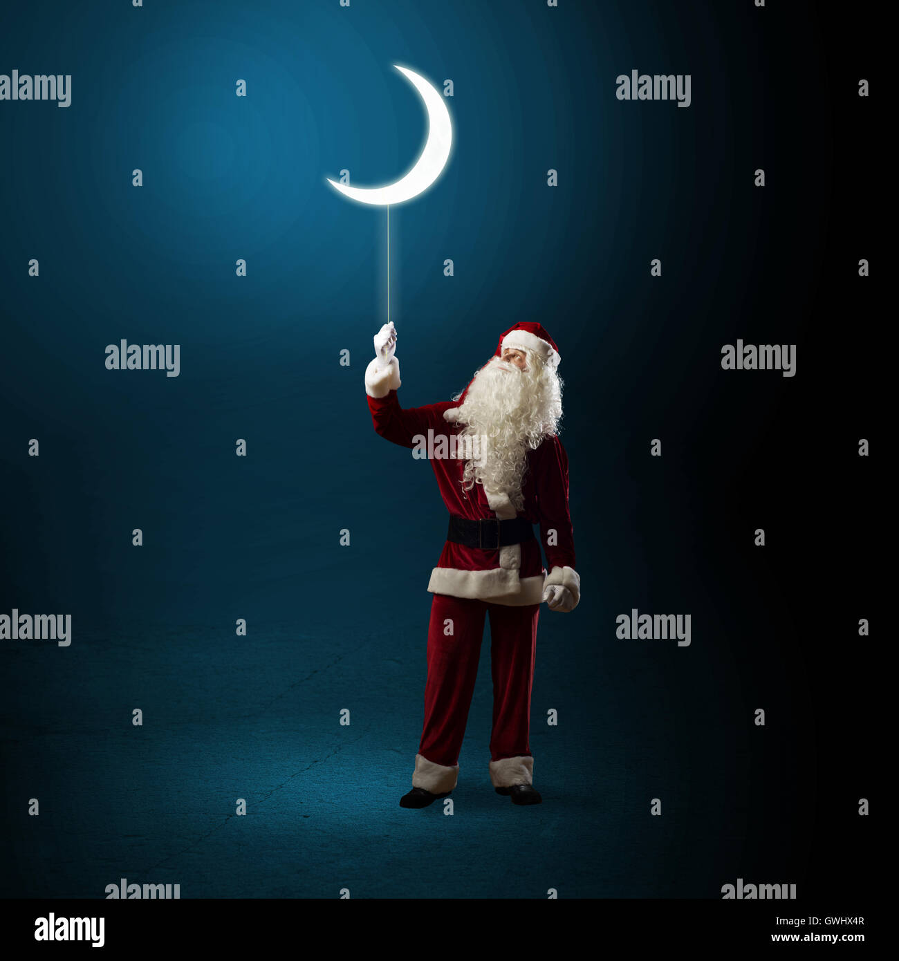 Santa Claus holding a shining moon Stock Photo - Alamy