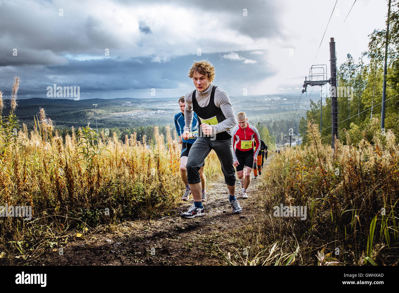 skyrunning group of runners running uphill on blue sky background ...
