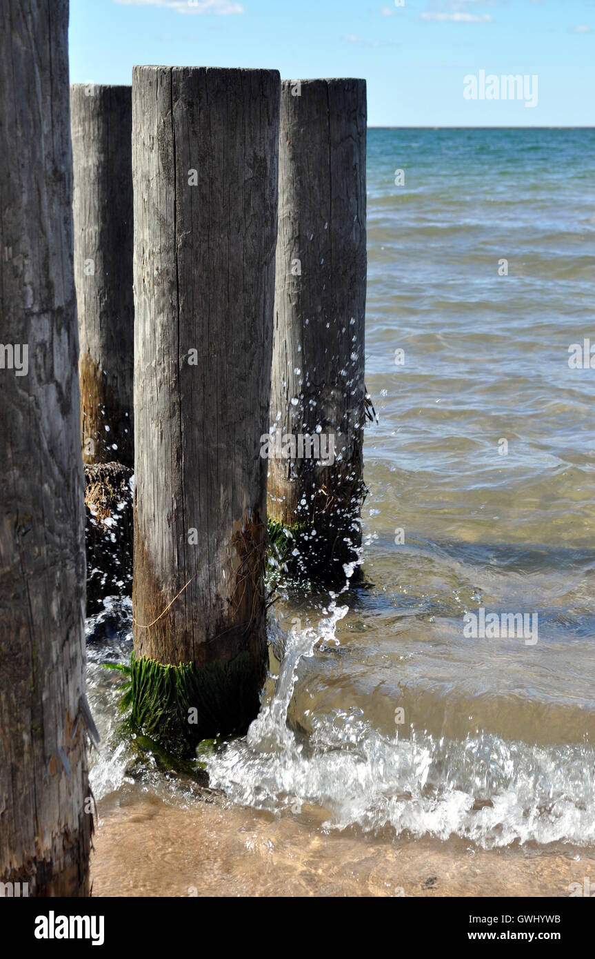 Wave breaks on the post Stock Photo - Alamy