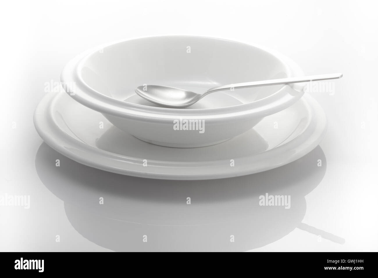 two plates and a spoon isolated on a white background Stock Photo - Alamy