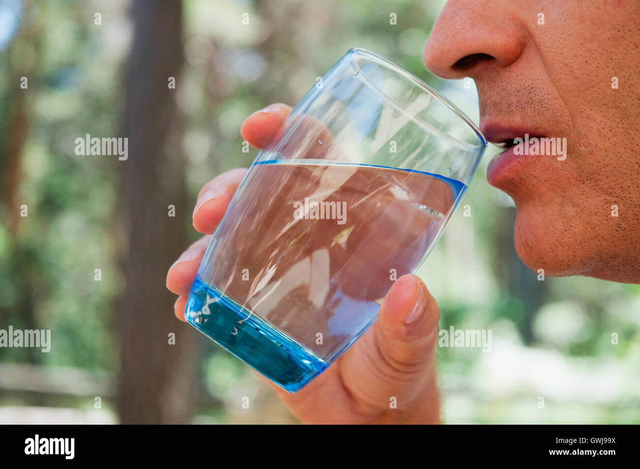 Man drinking a glass of water. Close view Stock Photo - Alamy