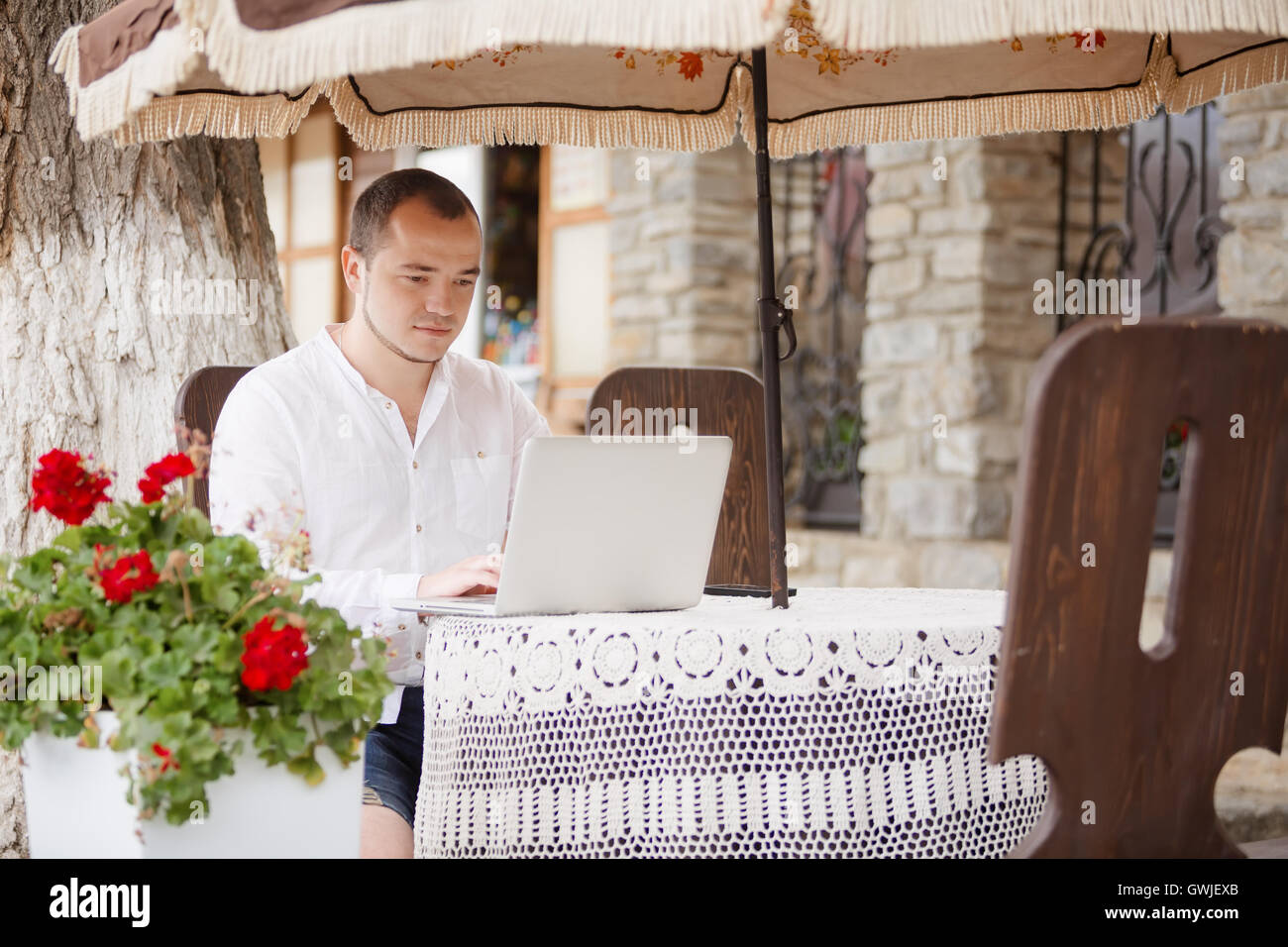 Man using a computer on an outdoor table Stock Photo - Alamy
