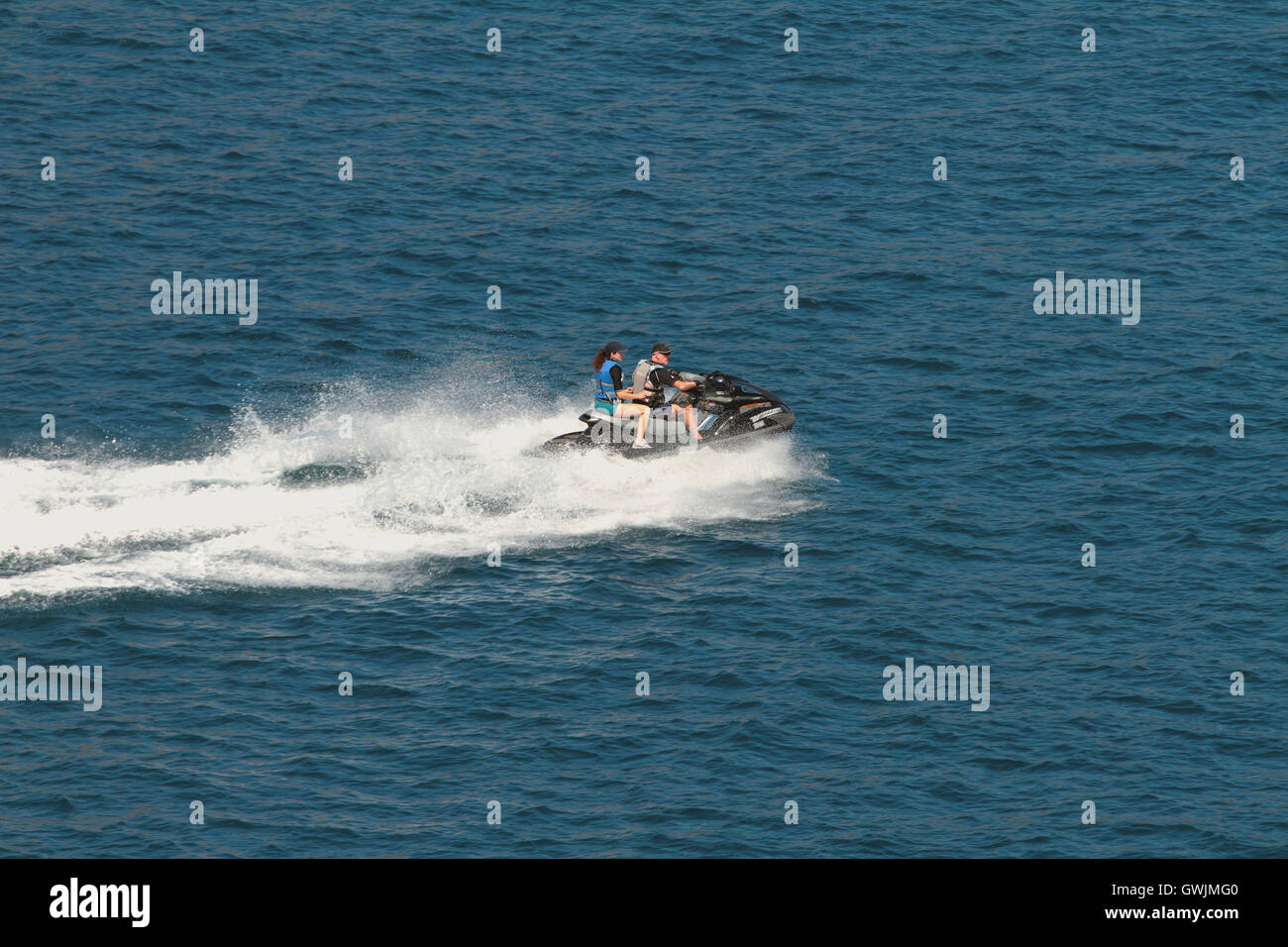 Man and woman on hydrocycle in sea Stock Photo - Alamy