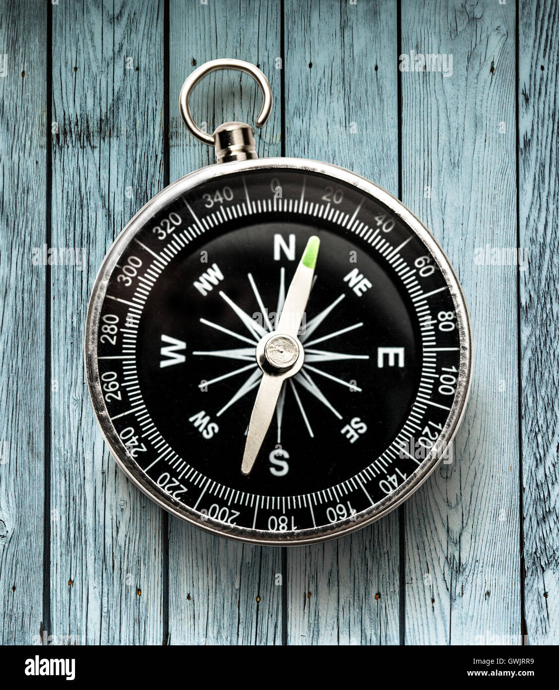 Black compass on wooden background in closeup Stock Photo - Alamy