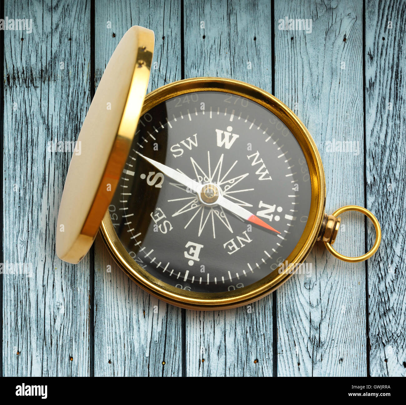 Golden vintage compass on wood in closeup Stock Photo - Alamy