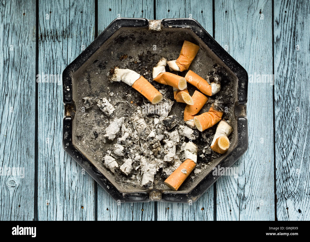 Ashtray with butts on the wooden background Stock Photo - Alamy