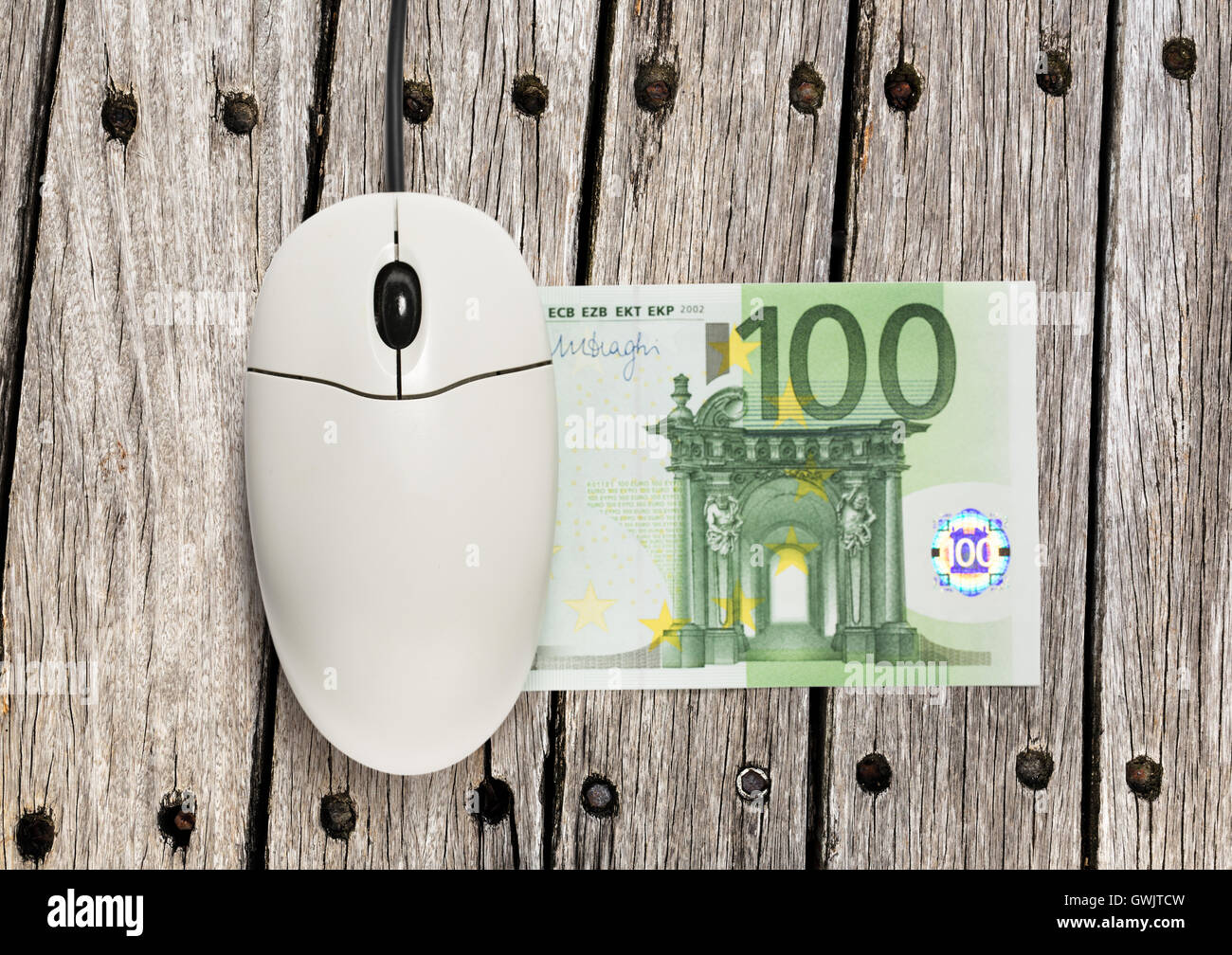 Computer mouse and one hundred euro banknote on wood Stock Photo - Alamy