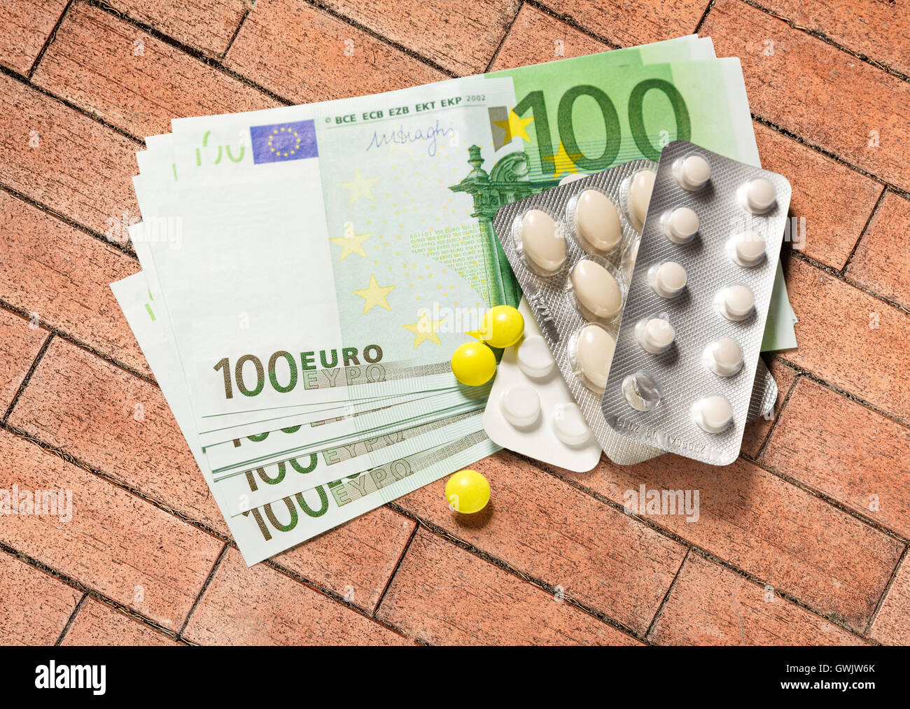 One hundred euro banknotes and pills closeup Stock Photo - Alamy