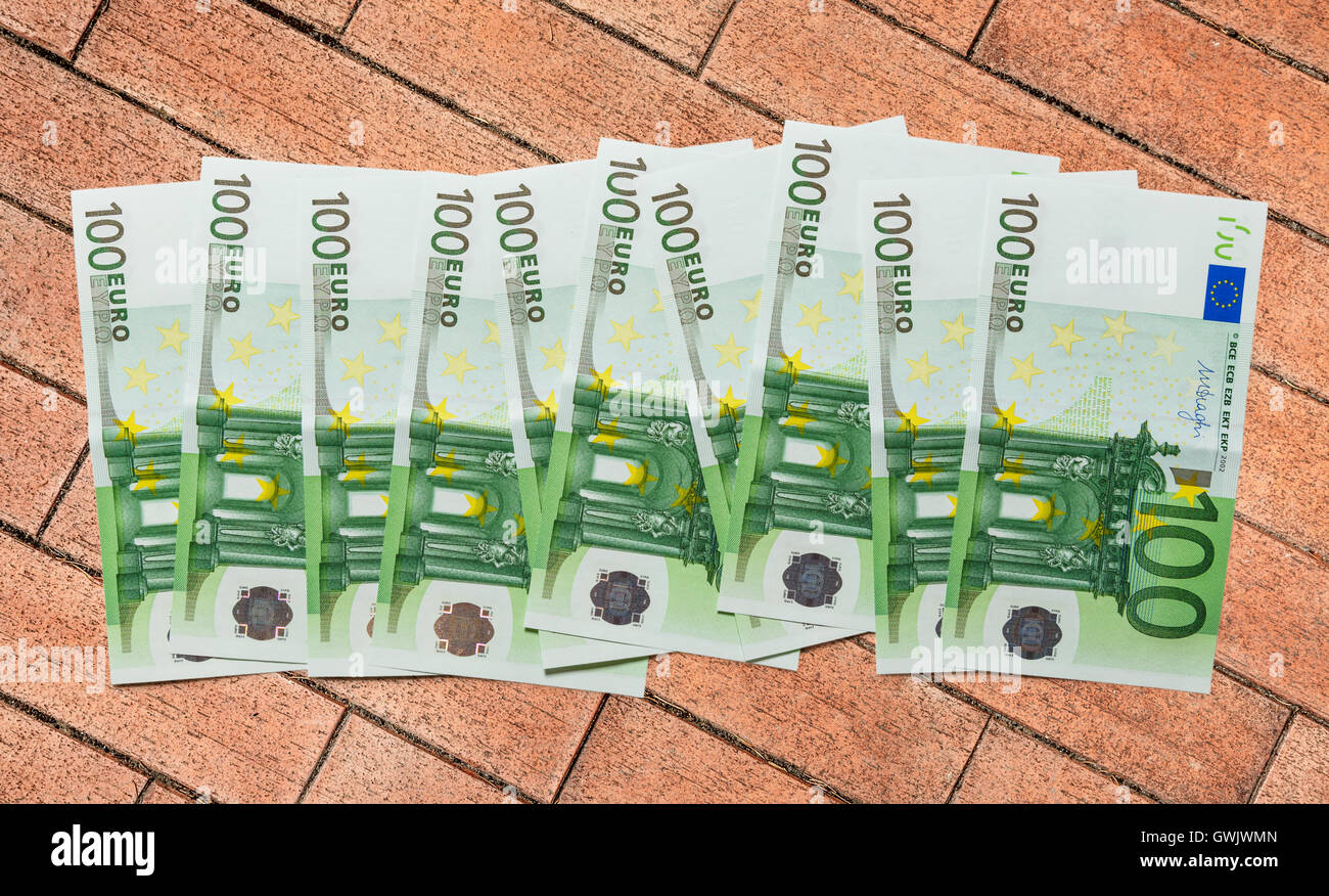 One hundred euro banknotes on brick background Stock Photo - Alamy