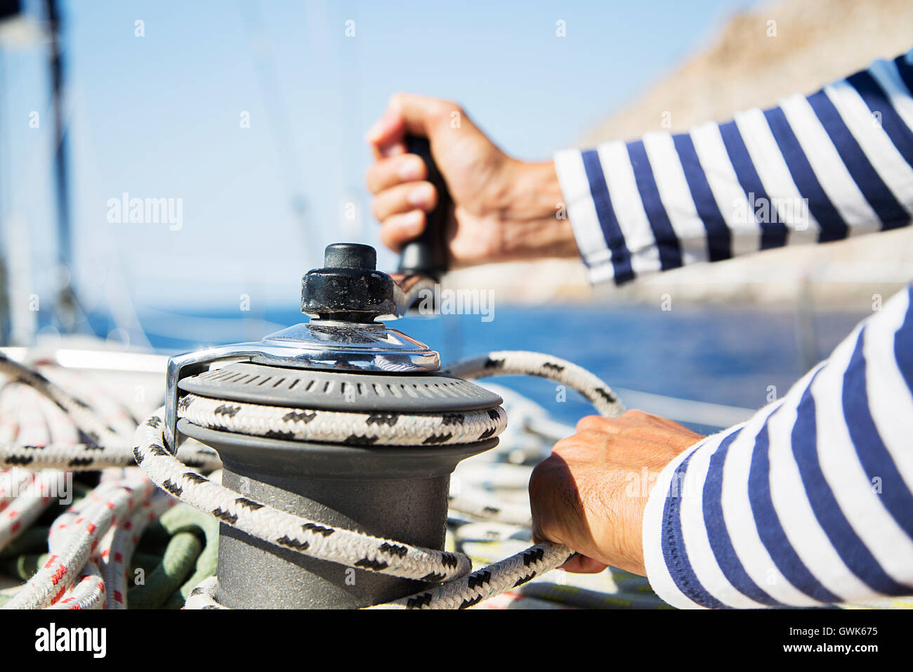 Young handsome sailor pulling rope on sailboat Stock Photo - Alamy