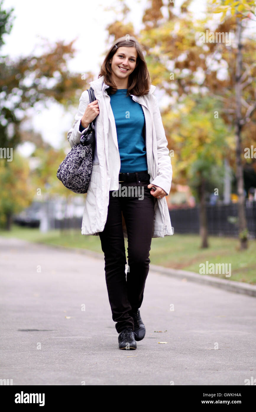 Full length, walking woman in autumn park Stock Photo - Alamy