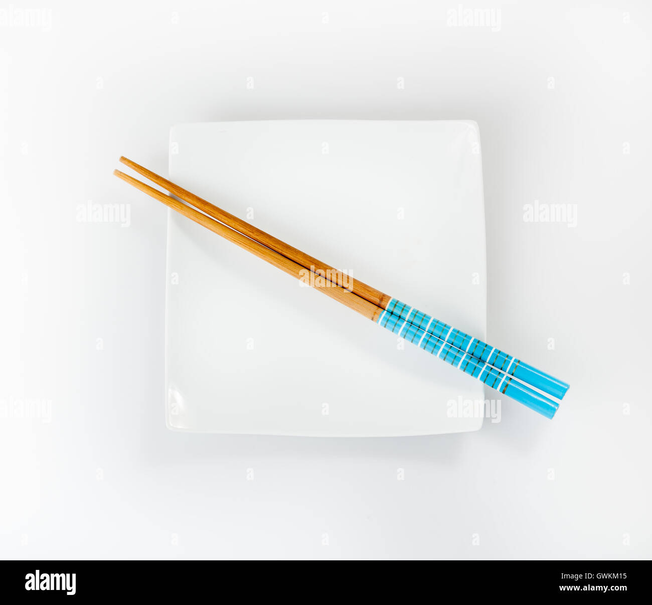 chopsticks on a plate isolated on a white background Stock Photo - Alamy