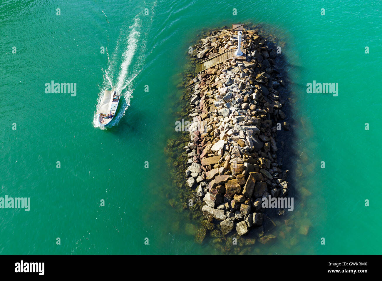 Wave breaker stone with ship Stock Photo - Alamy