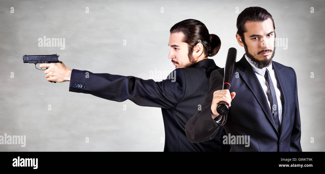 Collage with handsome man in suit with baseball bat and gun over gray ...