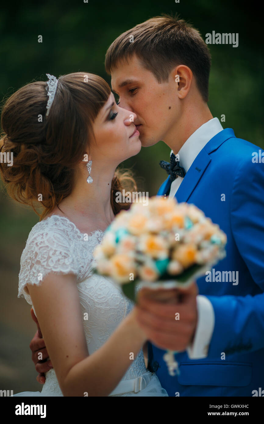 young bride and groom kissing on the background of the forest Stock ...