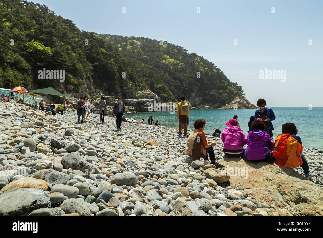 Korean tourists at a pebble rock beach at the Taejongdae Resort Park in ...