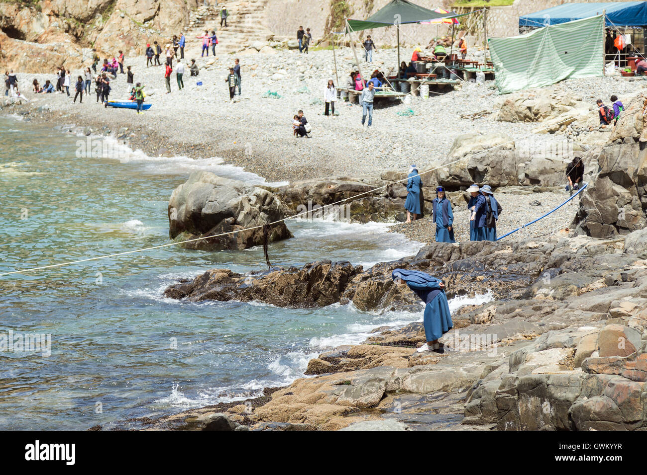 Nuns and other people at a pebble rock beach at the Taejongdae Resort ...